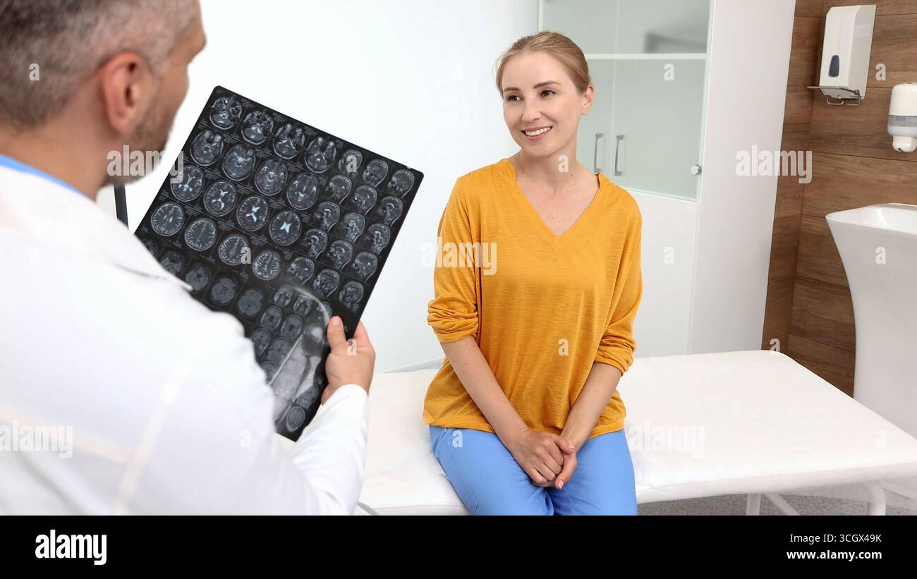 Doctor explaining to female patient results of MRI scan of her brain ...