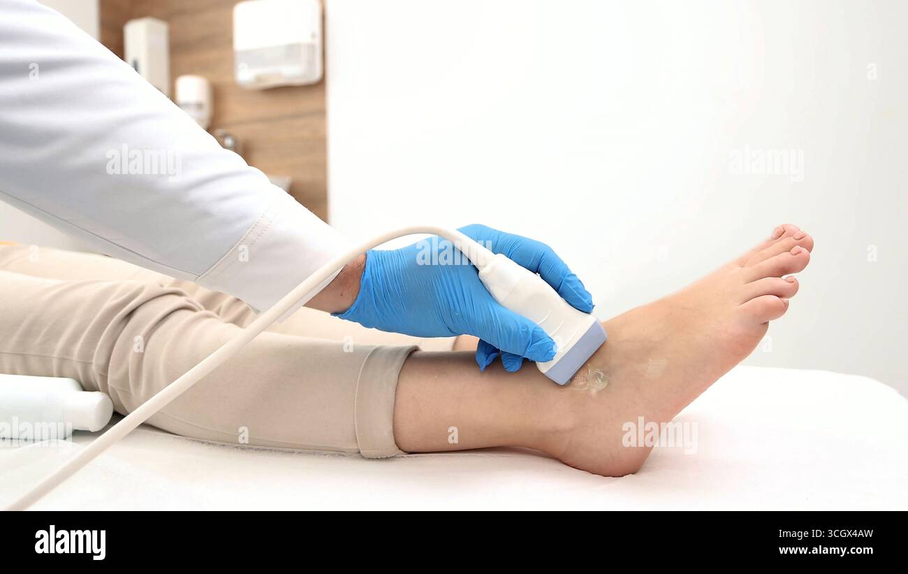 Ultrasonic of ankle joint. Sonographer checking patient ankle using ...