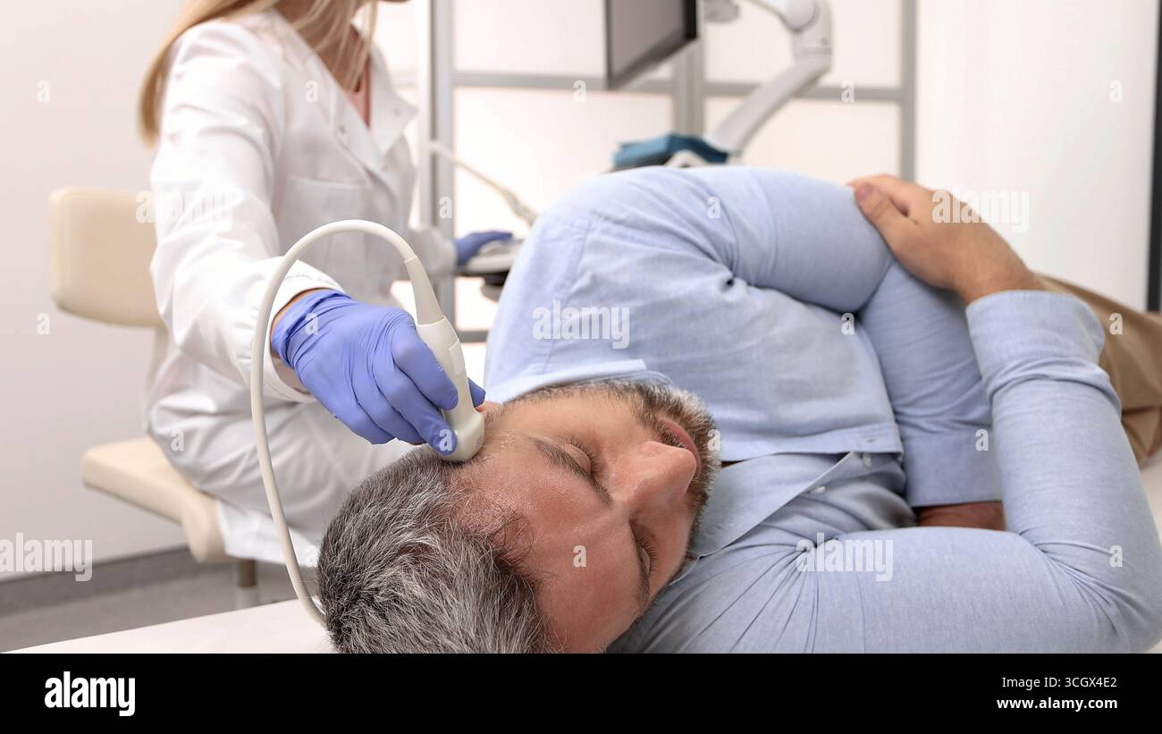 Sonographer examines brain of adult man by placing ultrasound ...