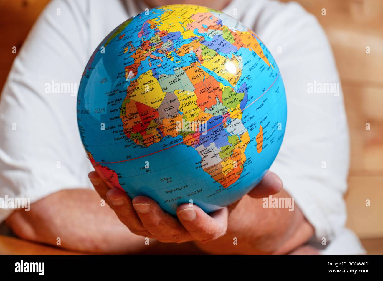 Bavaria, Germany - August 29, 2025: A hand holds the globe a symbol of ...