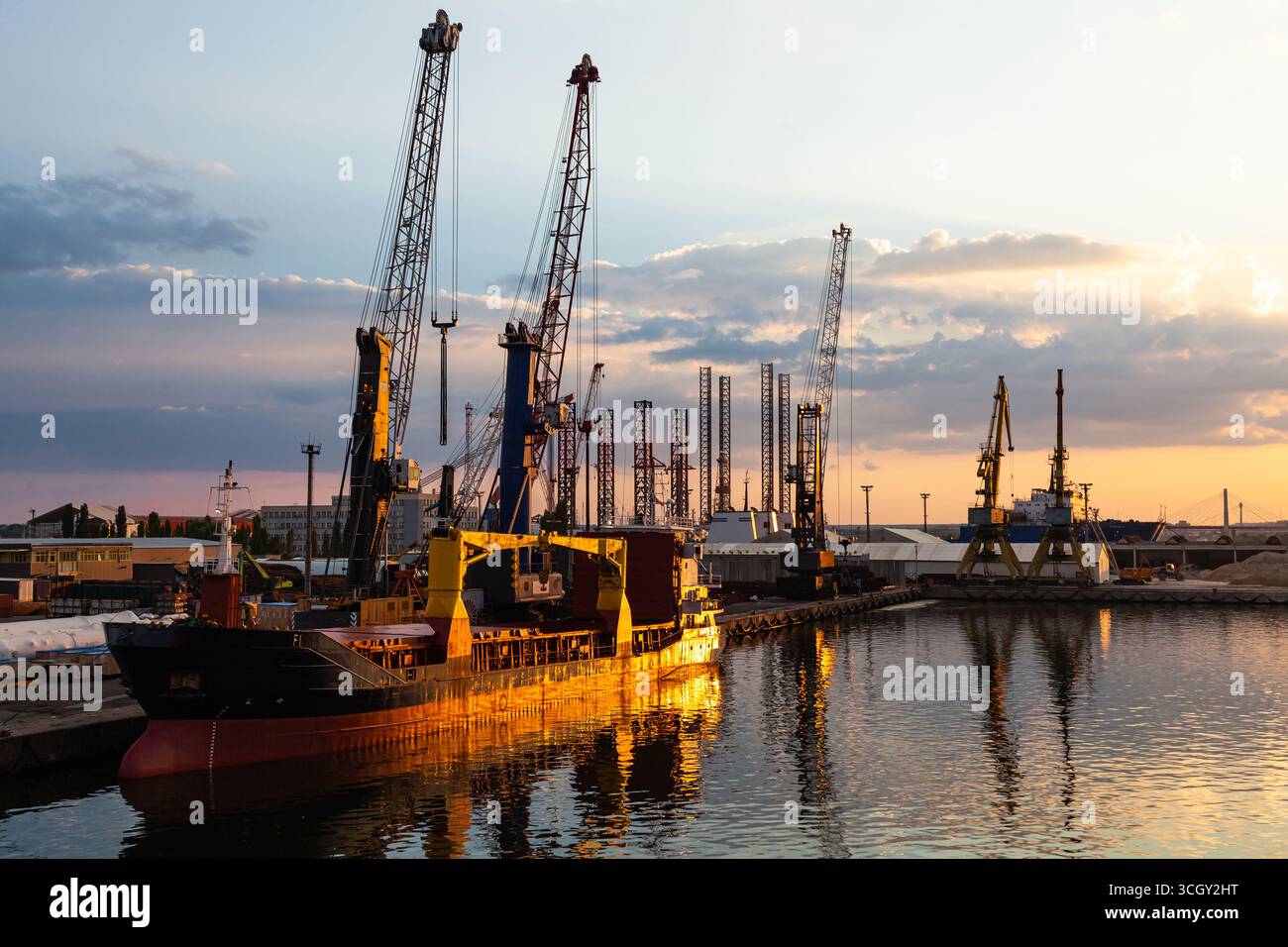 Sea port in Constanta, Romania at sunset with a moored cargo ship at ...