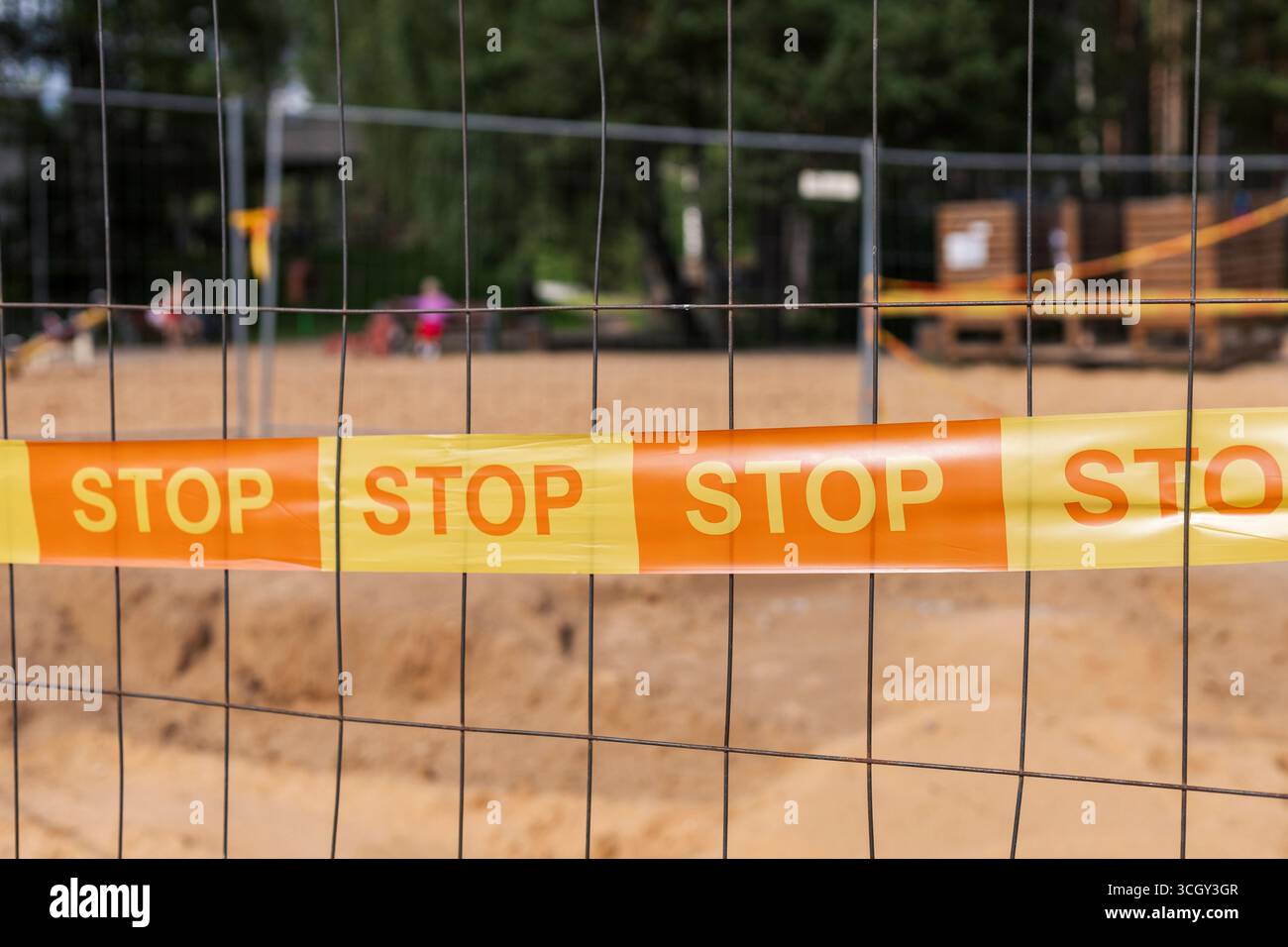 Bright orange stop tape marks off a sand area at a playground, warning ...