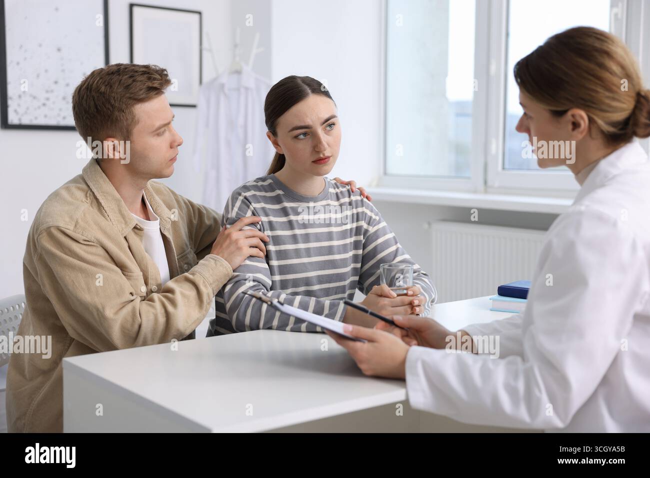 In vitro fertilization (IVF). Upset couple having appointment with ...