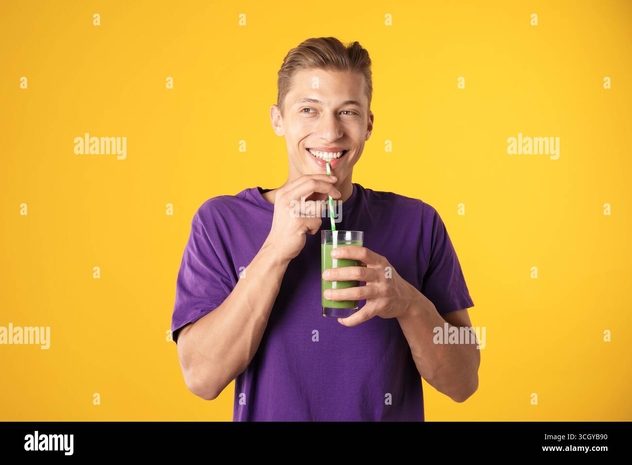 Man drinking juice through straw on orange background Stock Photo - Alamy