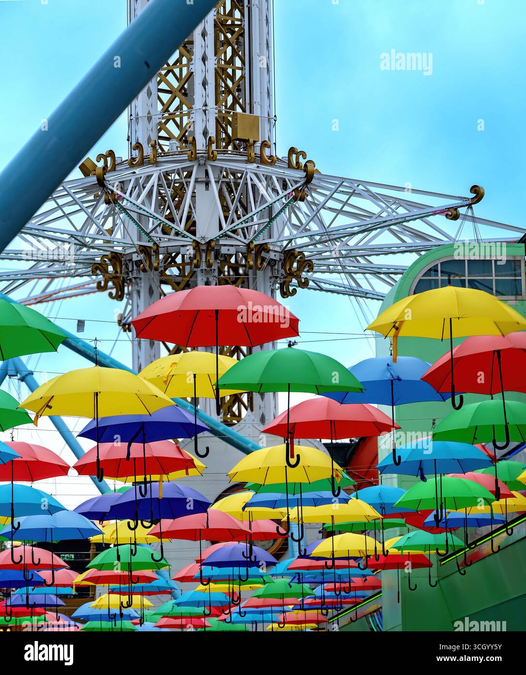 Colorful umbrellas in front of the construction of a modern chairoplane ...