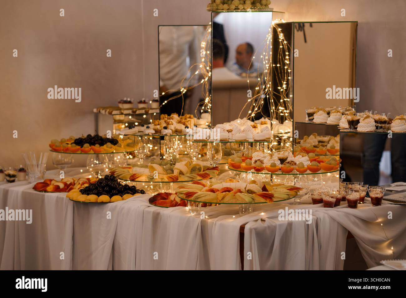 A lavish wedding dessert buffet displays a wide variety of fruit ...
