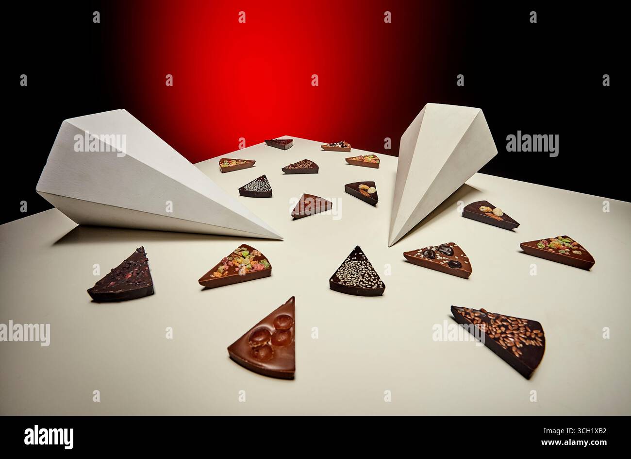 An artistic layout of broken chocolate bars spread across a white ...