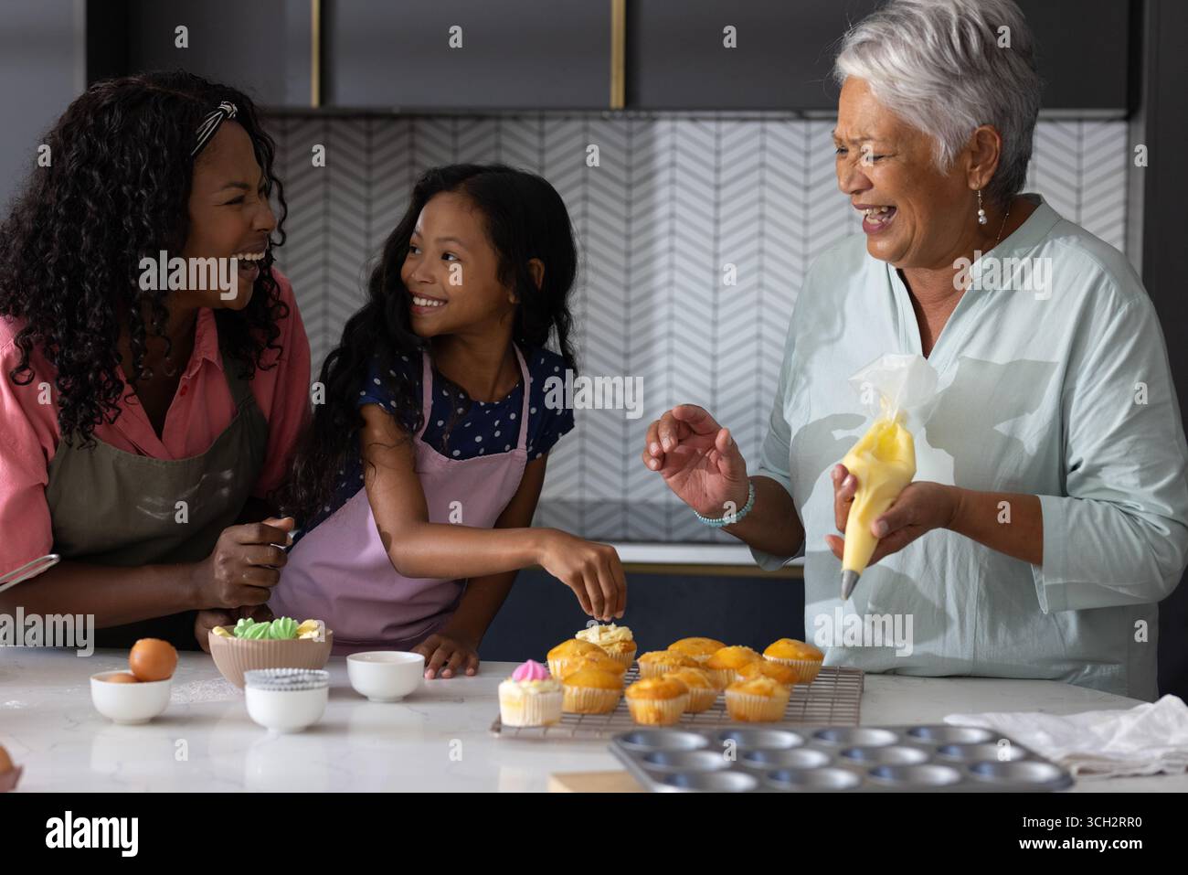 Baking cupcakes together, three generations of African American women ...