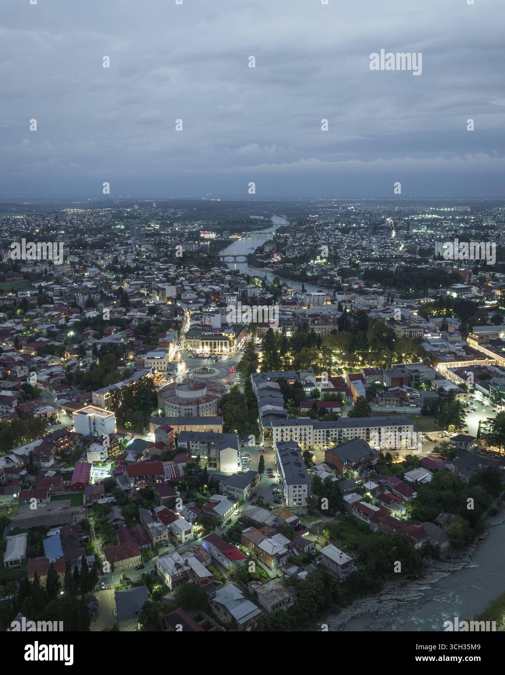 Aerial view of a city bathed in the soft glow of evening, the river ...