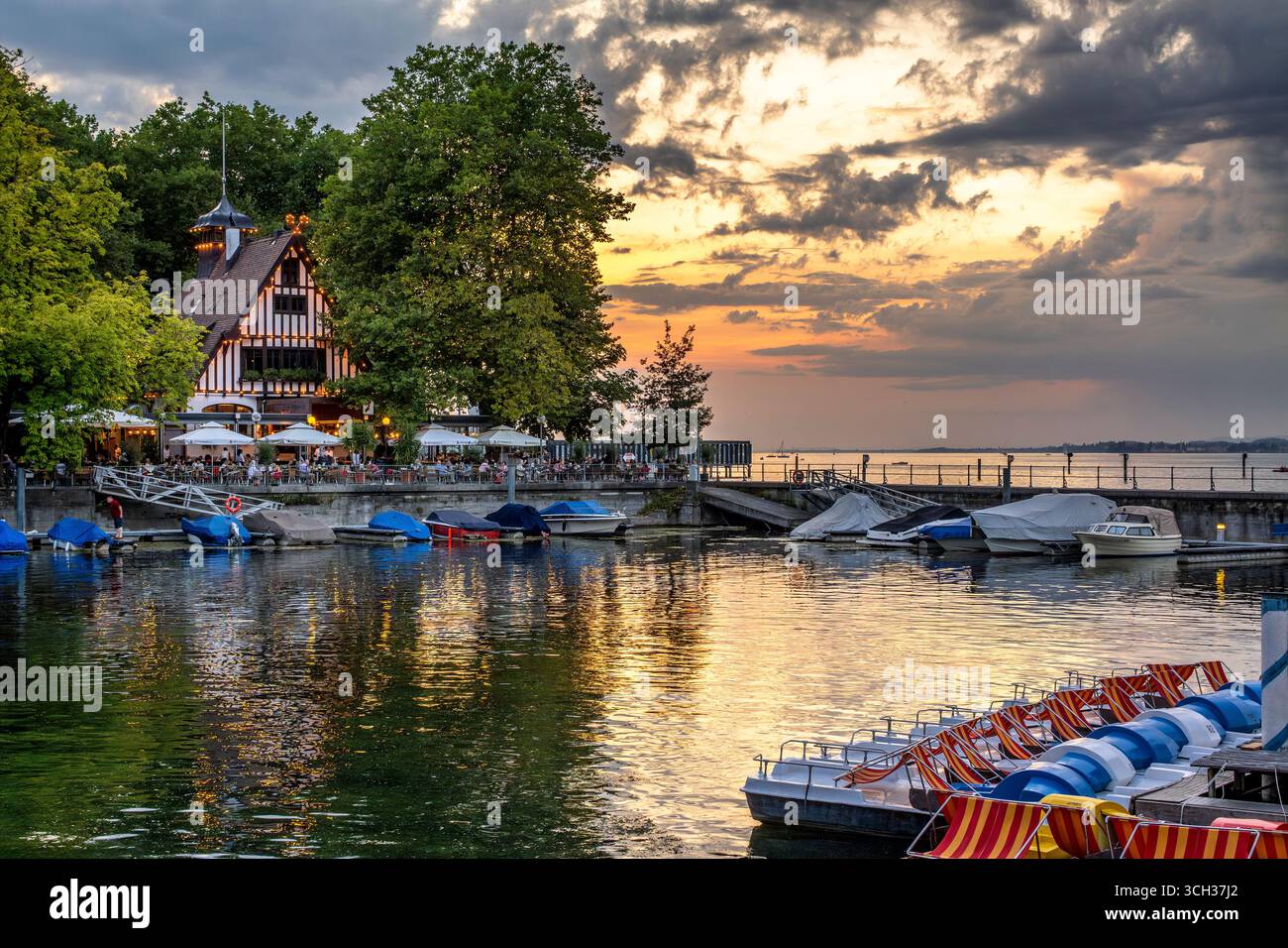 Boat rental and harbor with the Wirtshaus am See at sunset on the lake ...