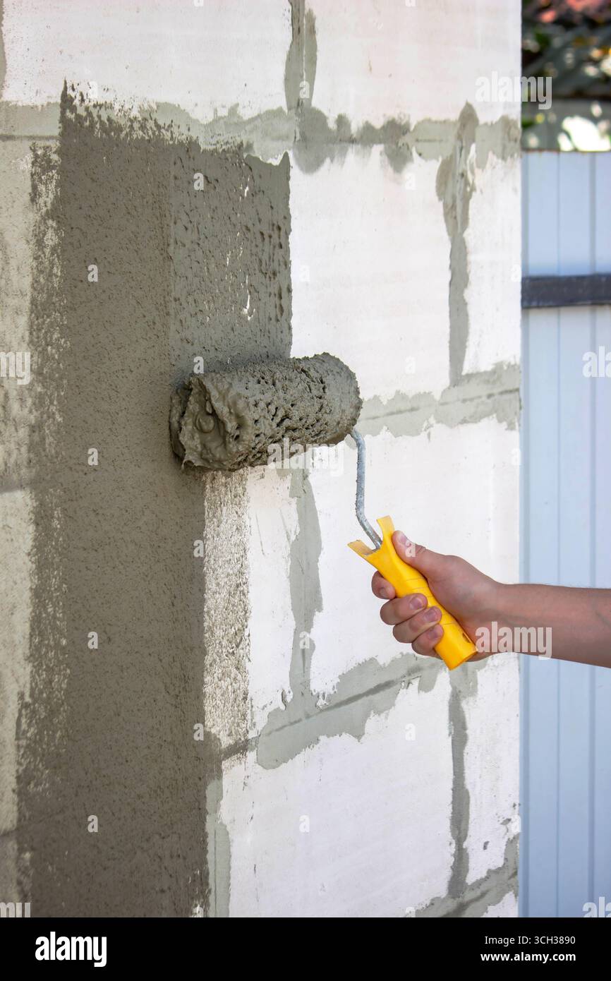Worker Applying Plaster with Roller Stock Photo - Alamy