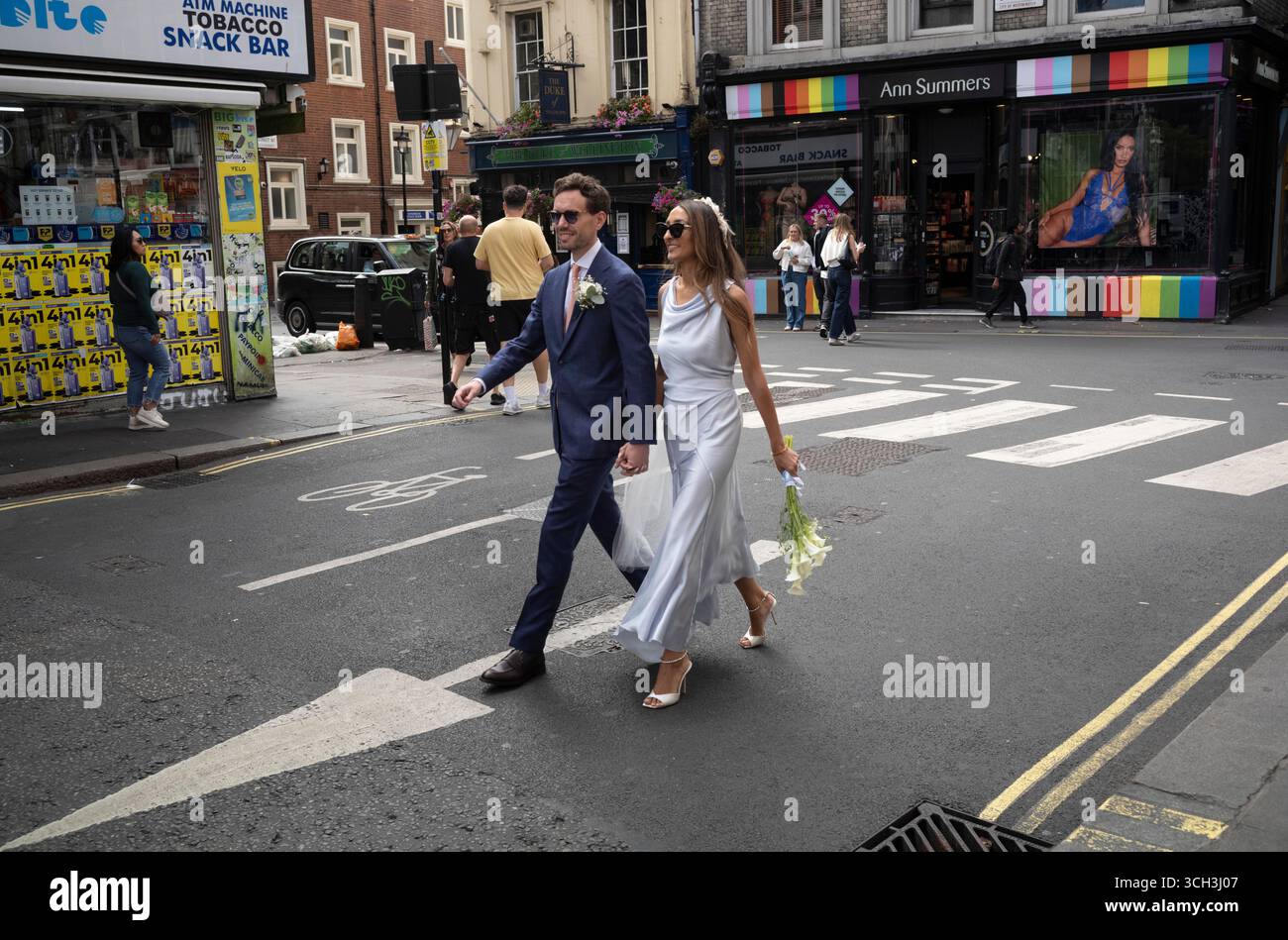 Newly married couple walk along Old Compton Street, in the heart of ...