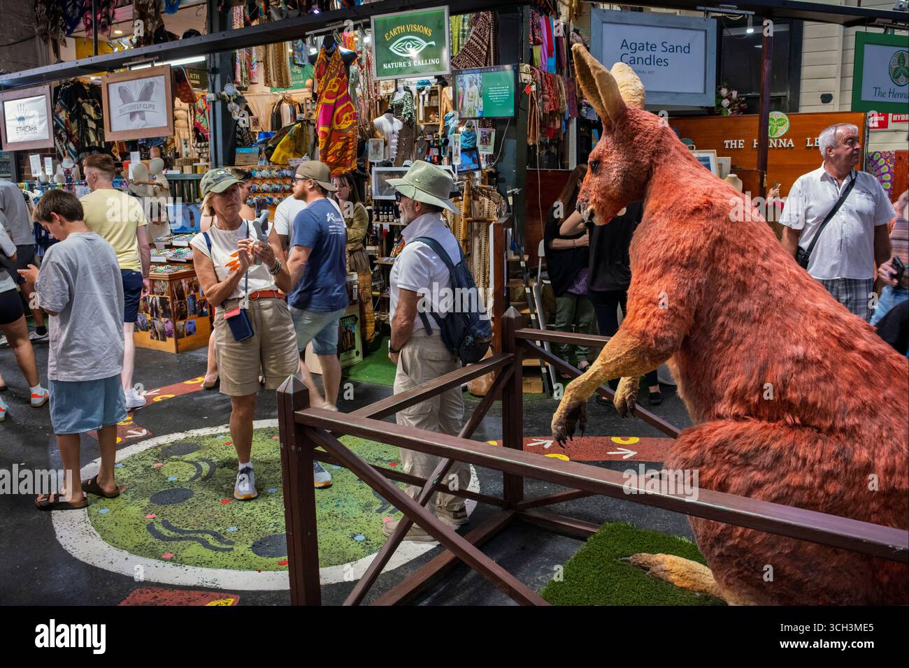 A tourist taking a photo of her partner by the giant red kangaroo ...