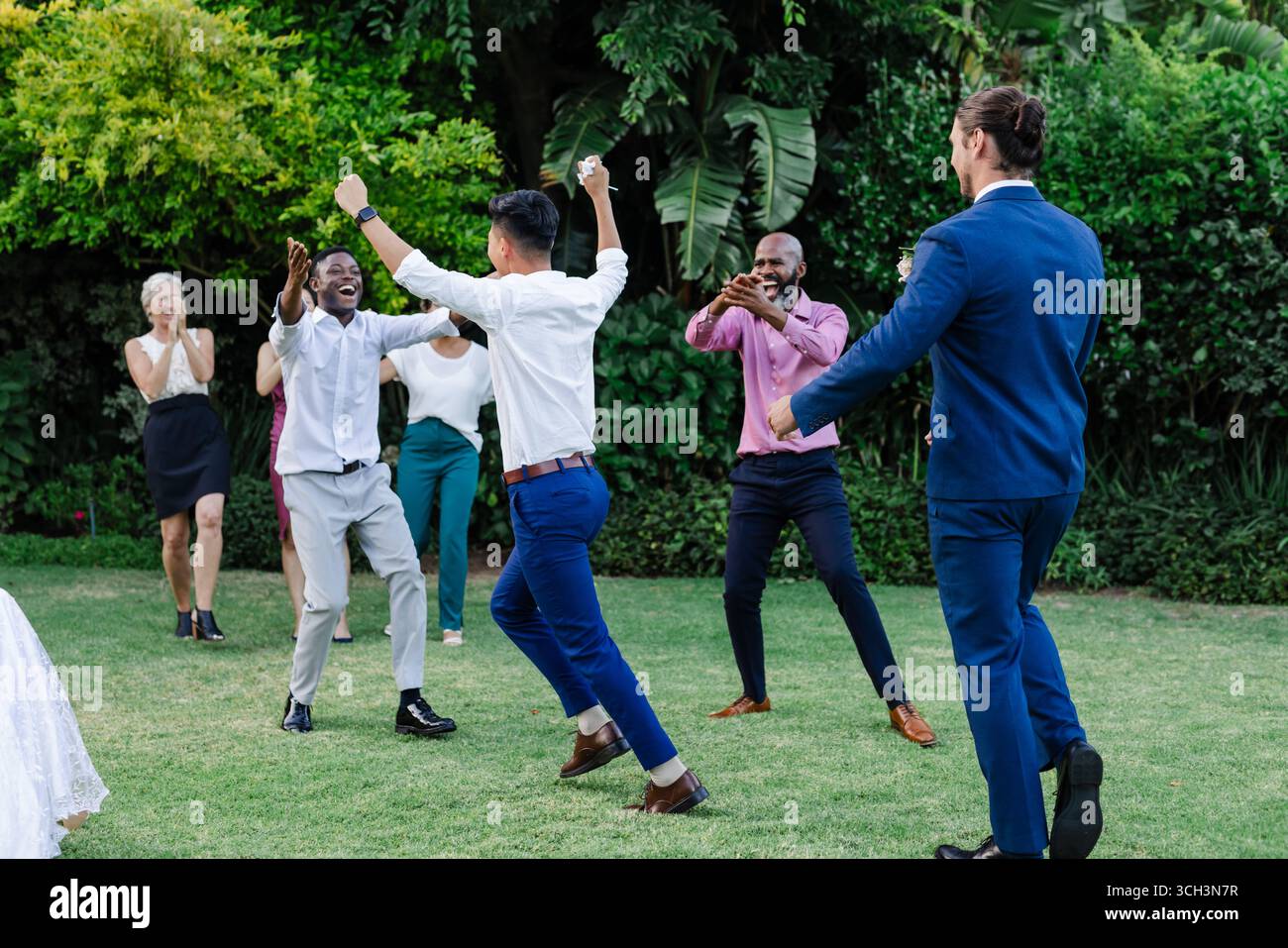 Celebrating joyfully, guests dancing energetically at outdoor wedding ...
