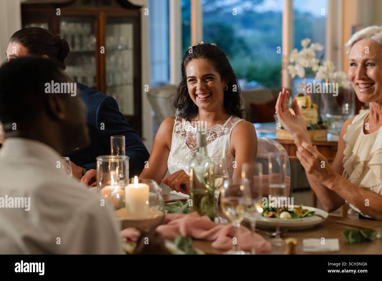 Guests enjoying dinner, smiling and clapping at elegant wedding ...