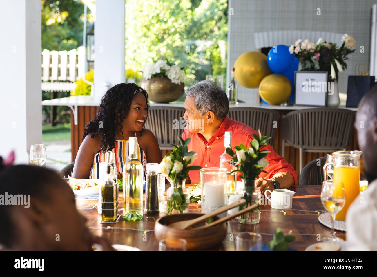 Diverse family celebrating retirement with joyful conversation at in ...