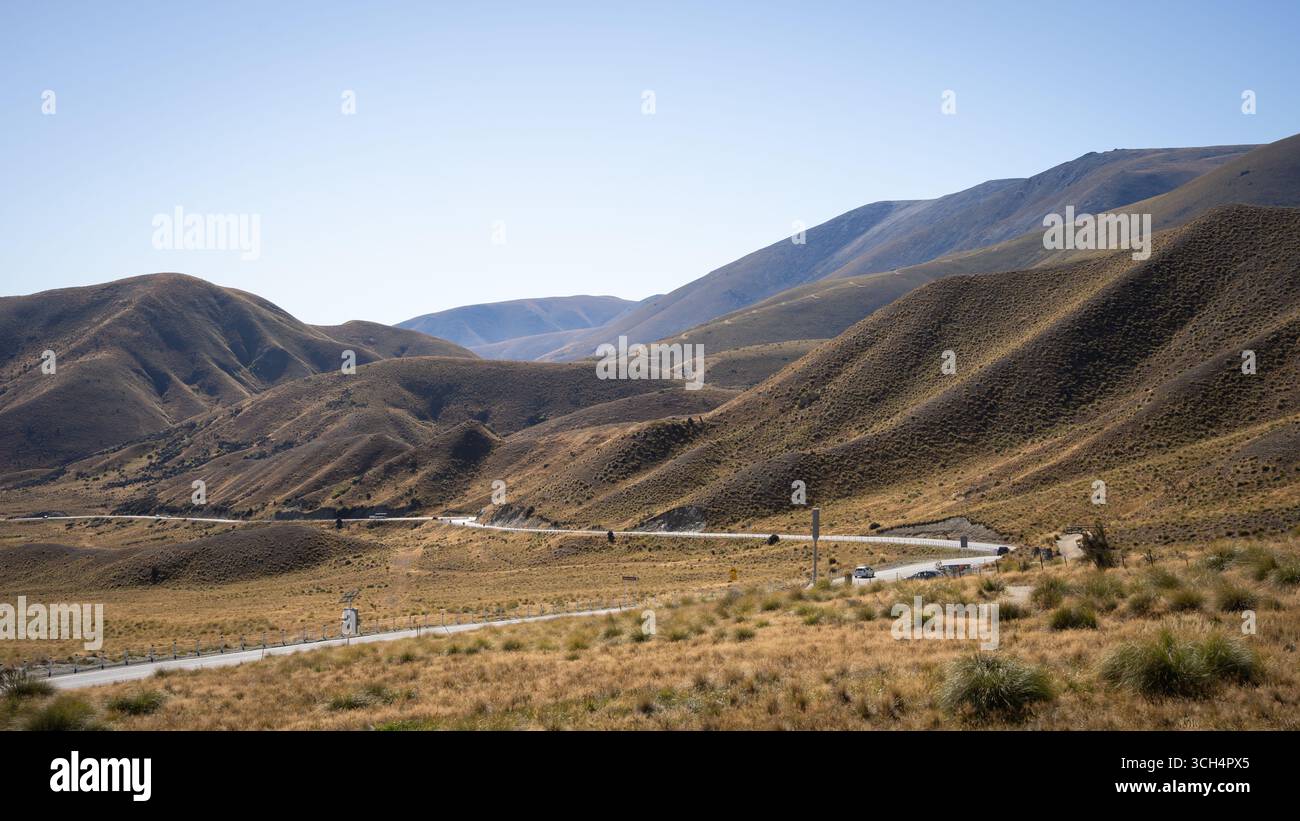 Highway running through hilly valley with no trees, Lindis Pass, New ...