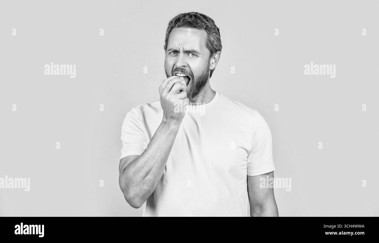 healthy man bite vitamin fruit in studio. photo of healthy man with ...