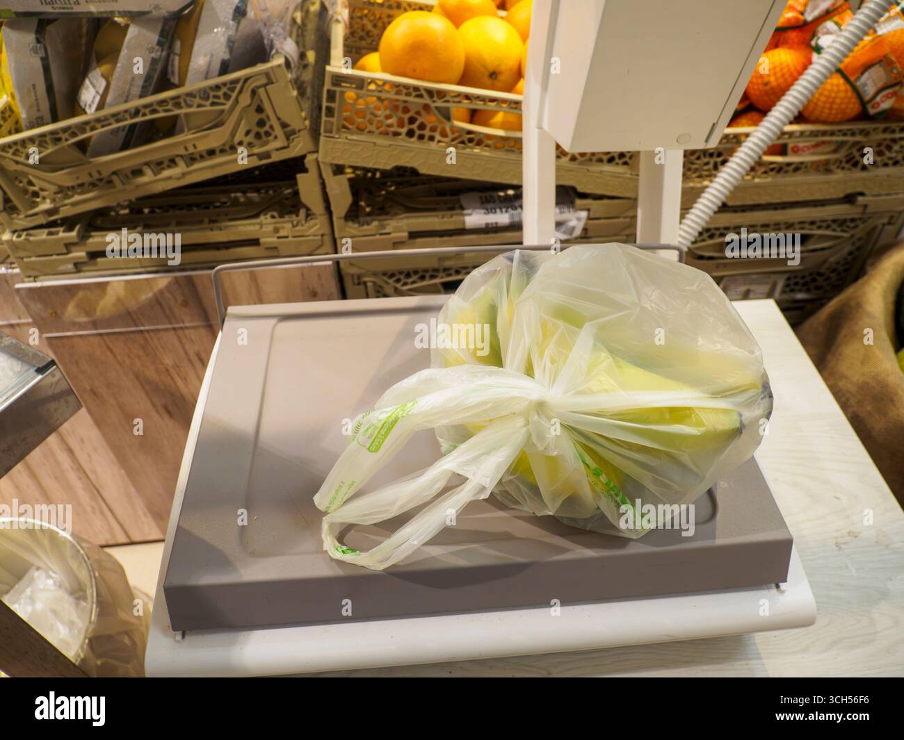 Cremona, Italy - August 14th 2025 Customer weighing fresh produce in a ...