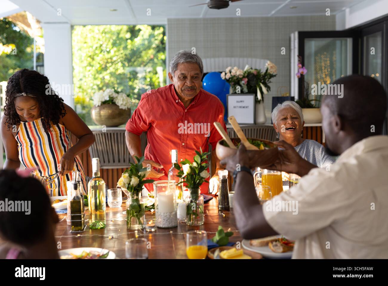 Family enjoying outdoor meal together, sharing laughter and ...