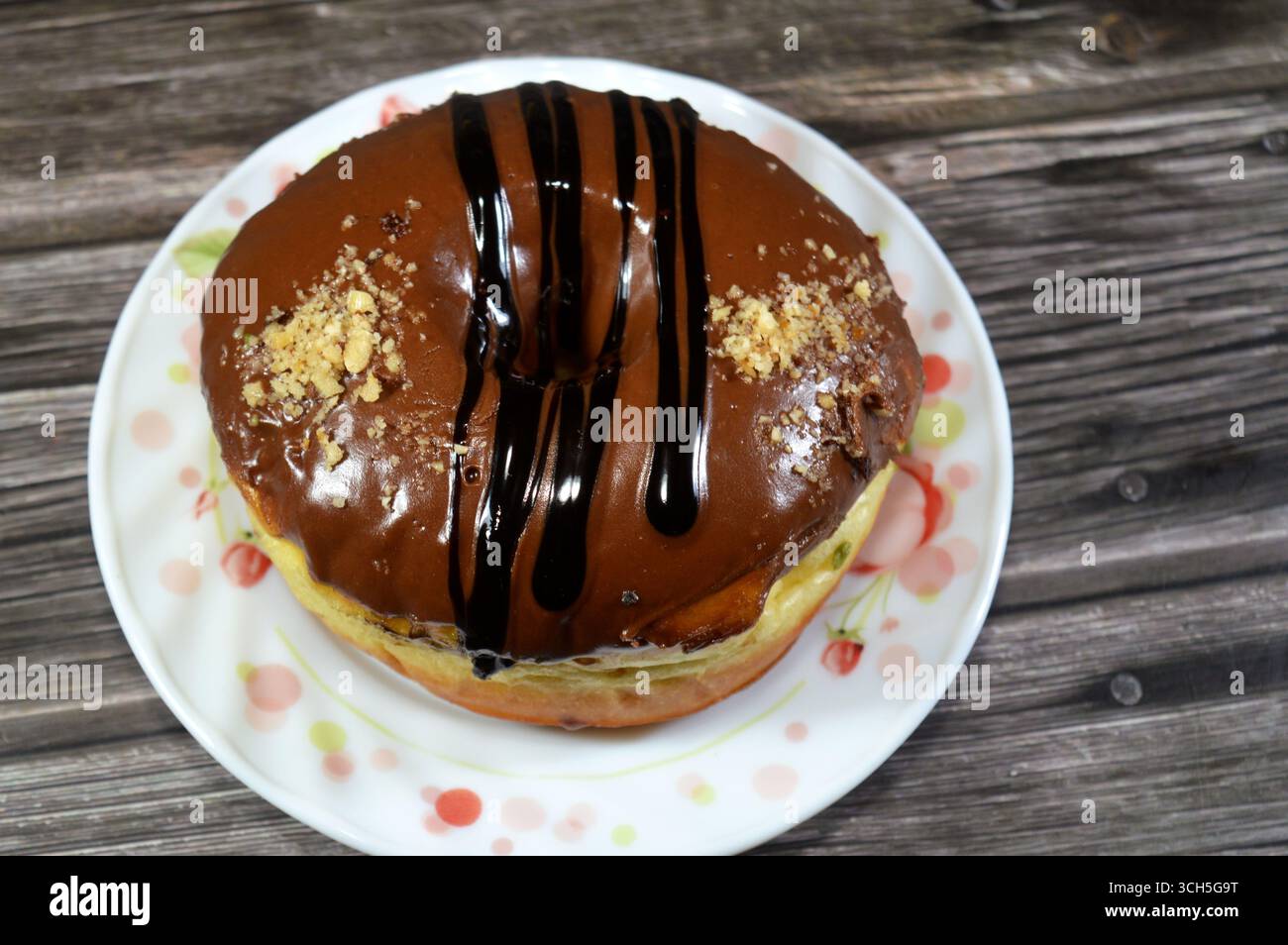 Chocolate topping and dark chocolate sauce and hazelnut pieces on a ...