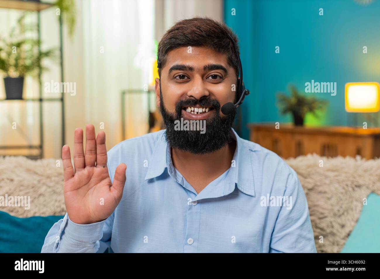 Indian man at home with headset microphone speaks as help line operator ...