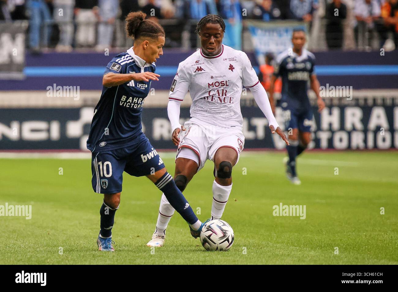 Paris FC's Ilan Kebbal, left, challenges for the ball with Metz's ...