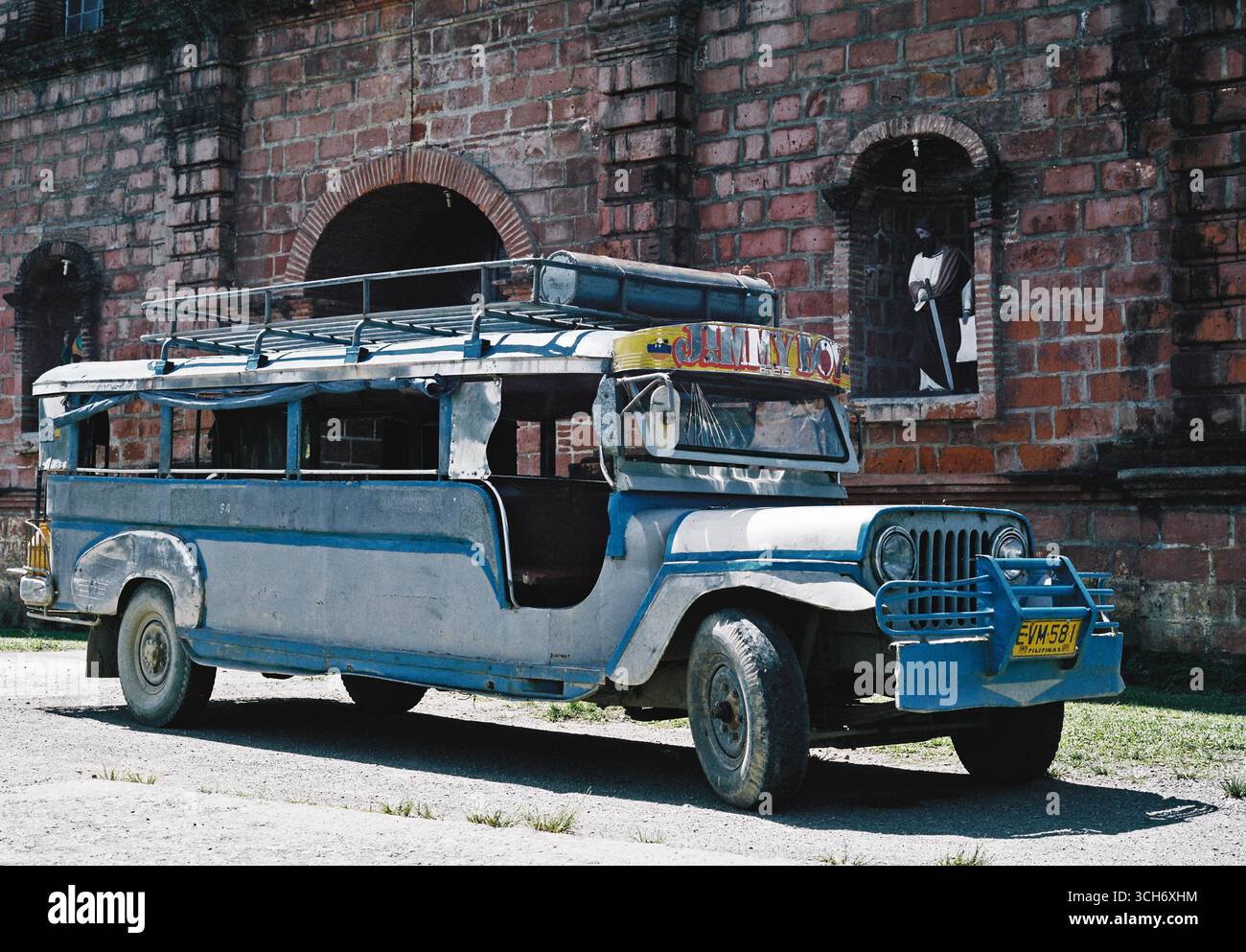 A traditional Filipino jeepney parked in the courtyard of a Catholic ...