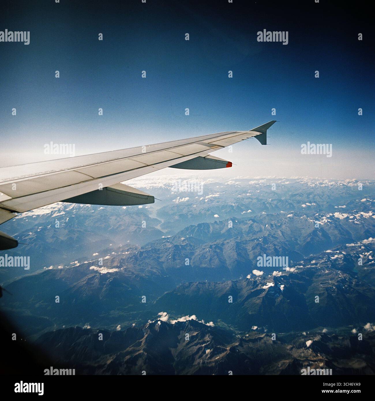 View of the Alps through a commercial airplane window, with the ...