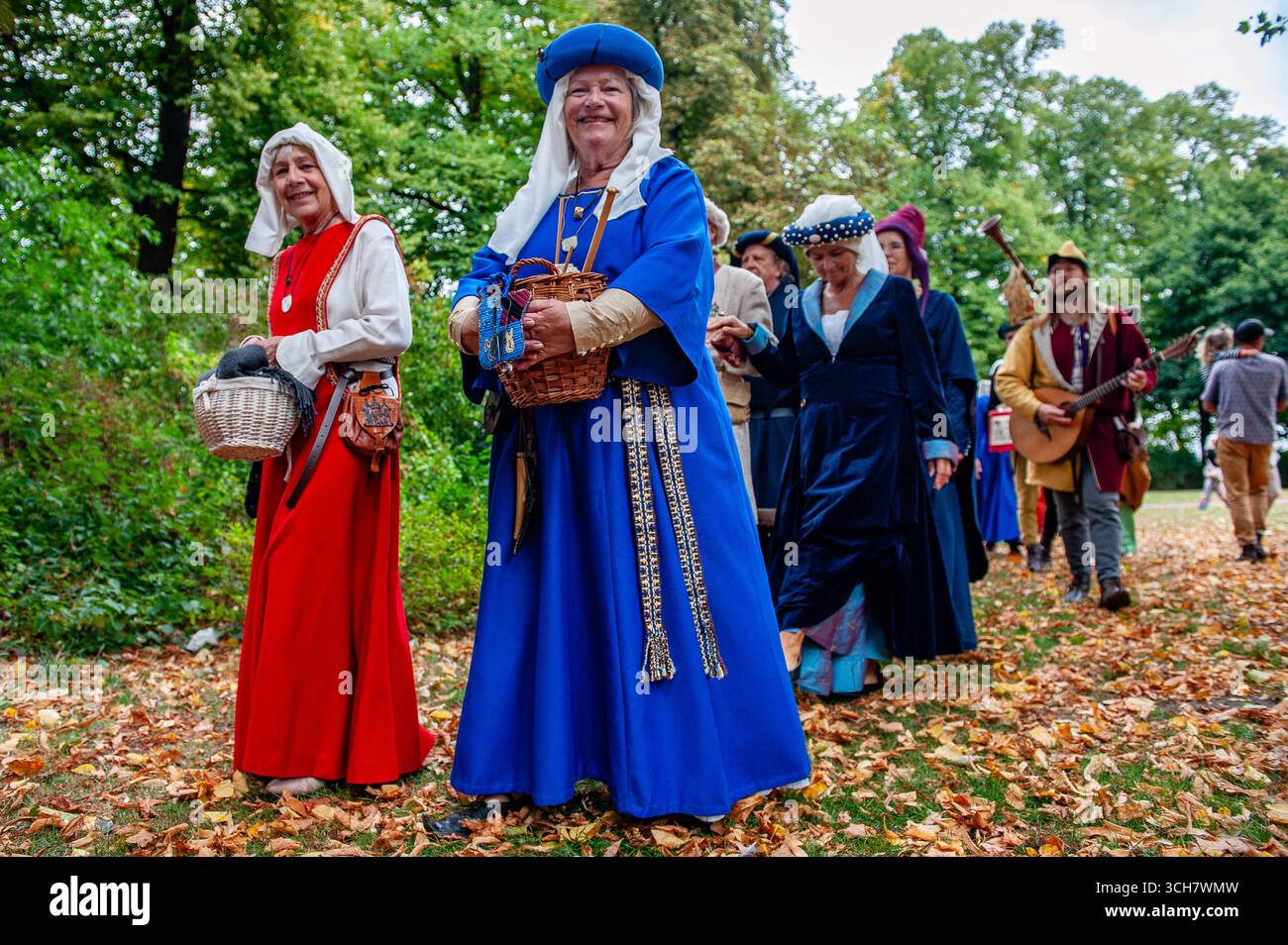 Women dressed in Medieval costumes are seen walking at the park. At the ...