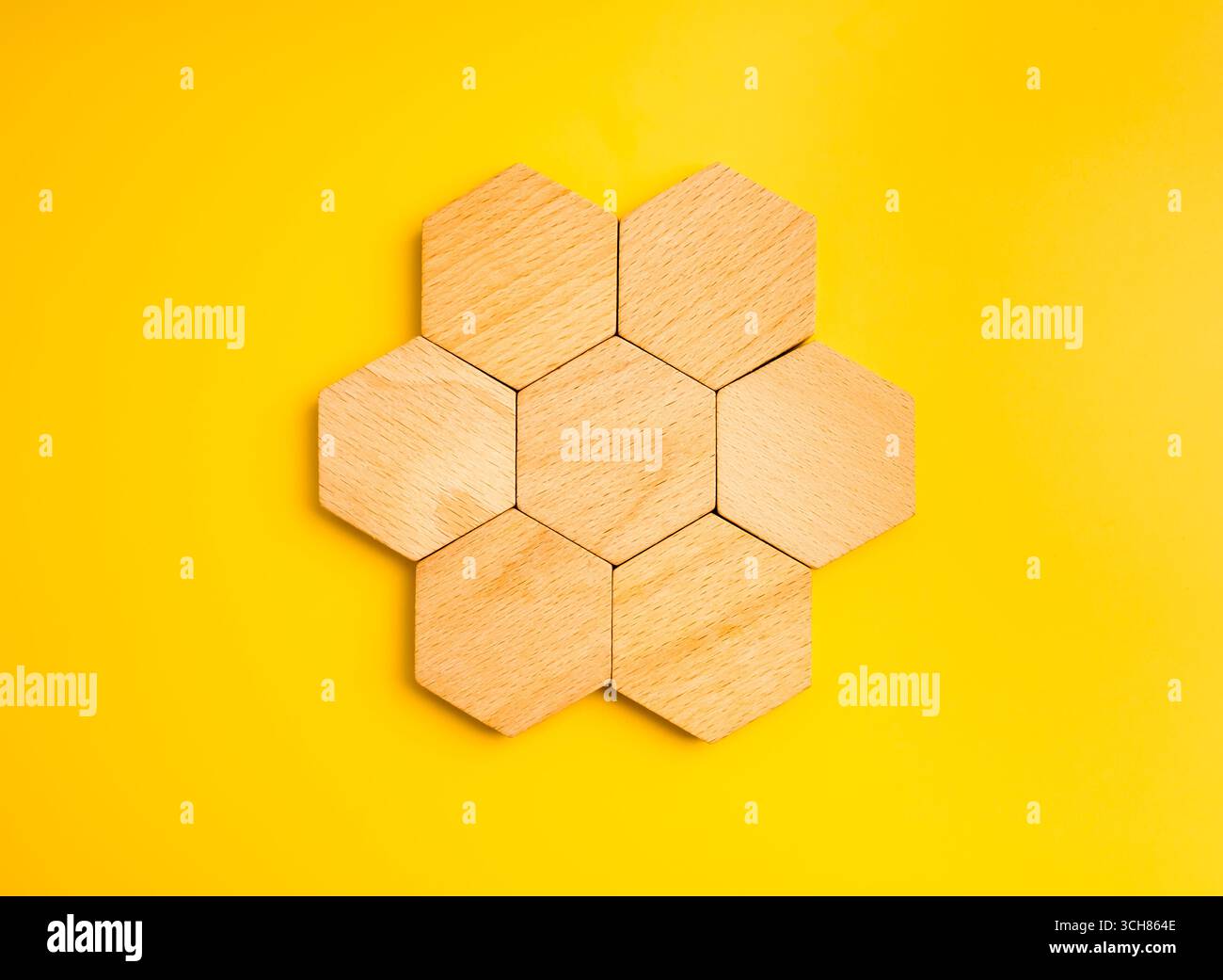 Blank wooden hexagon blocks arranged in honeycomb structure on yellow ...
