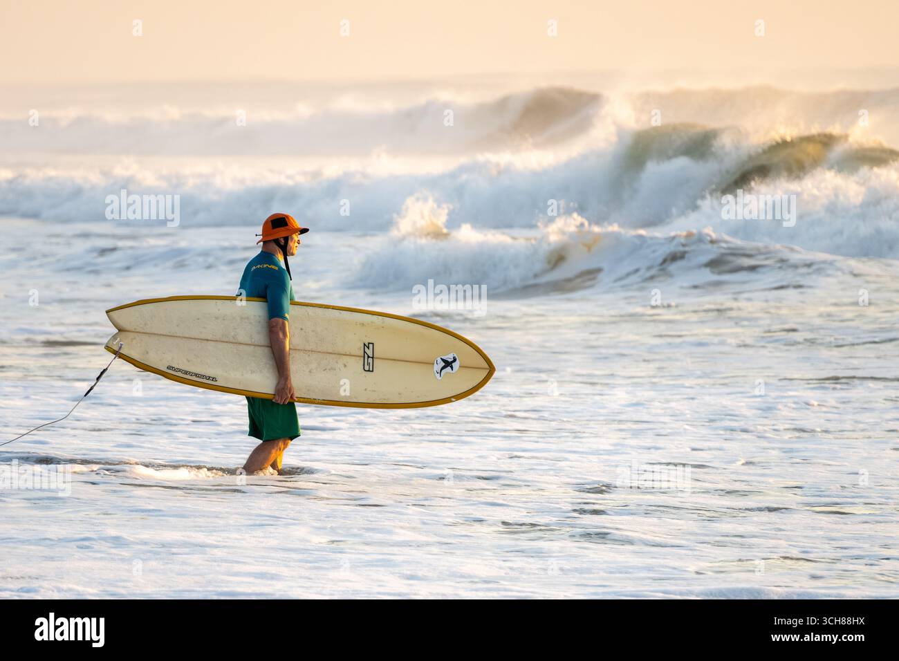 Fit, older surfer entering the surf at sunrise in Fernandina Beach on ...