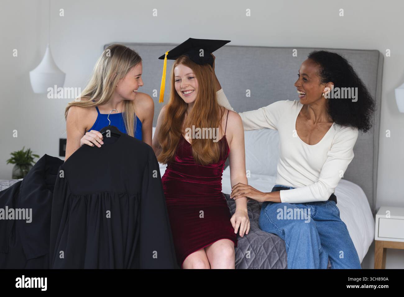 Family celebrating teen's graduation at home, smiling and sharing ...