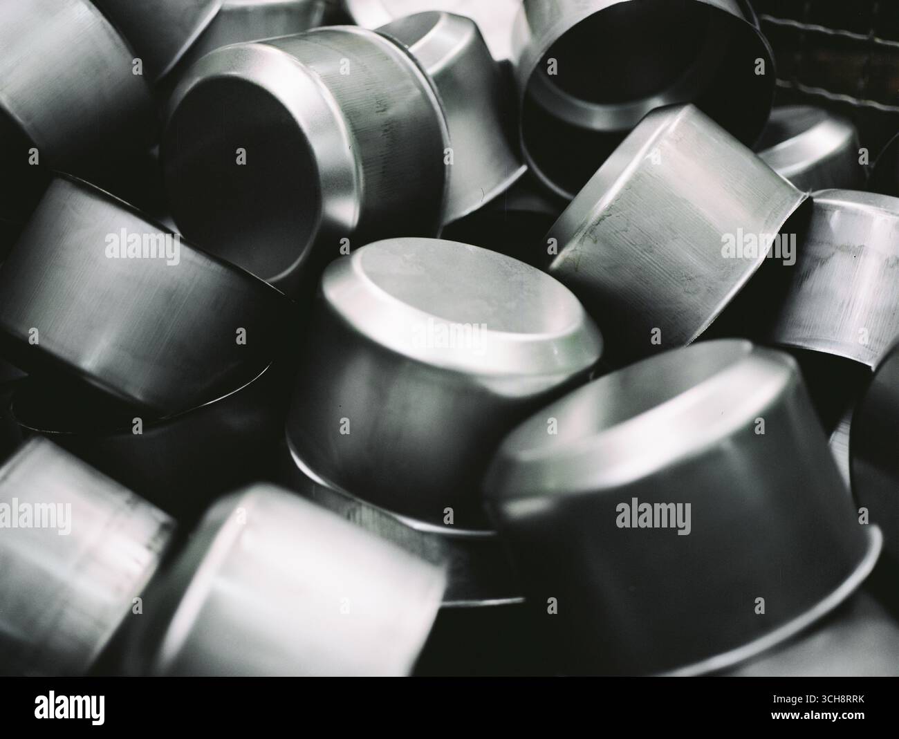 pile of unpainted metal mugs, captured before the finishing process ...