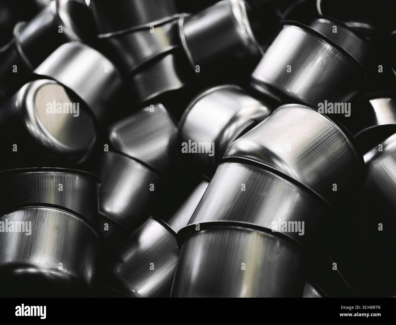pile of unpainted metal mugs, captured before the finishing process ...