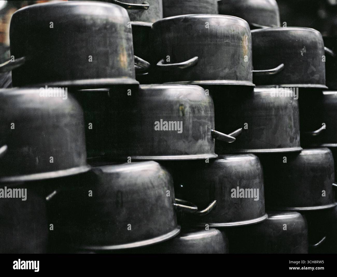 pile of unpainted metal mugs, captured before the finishing process ...