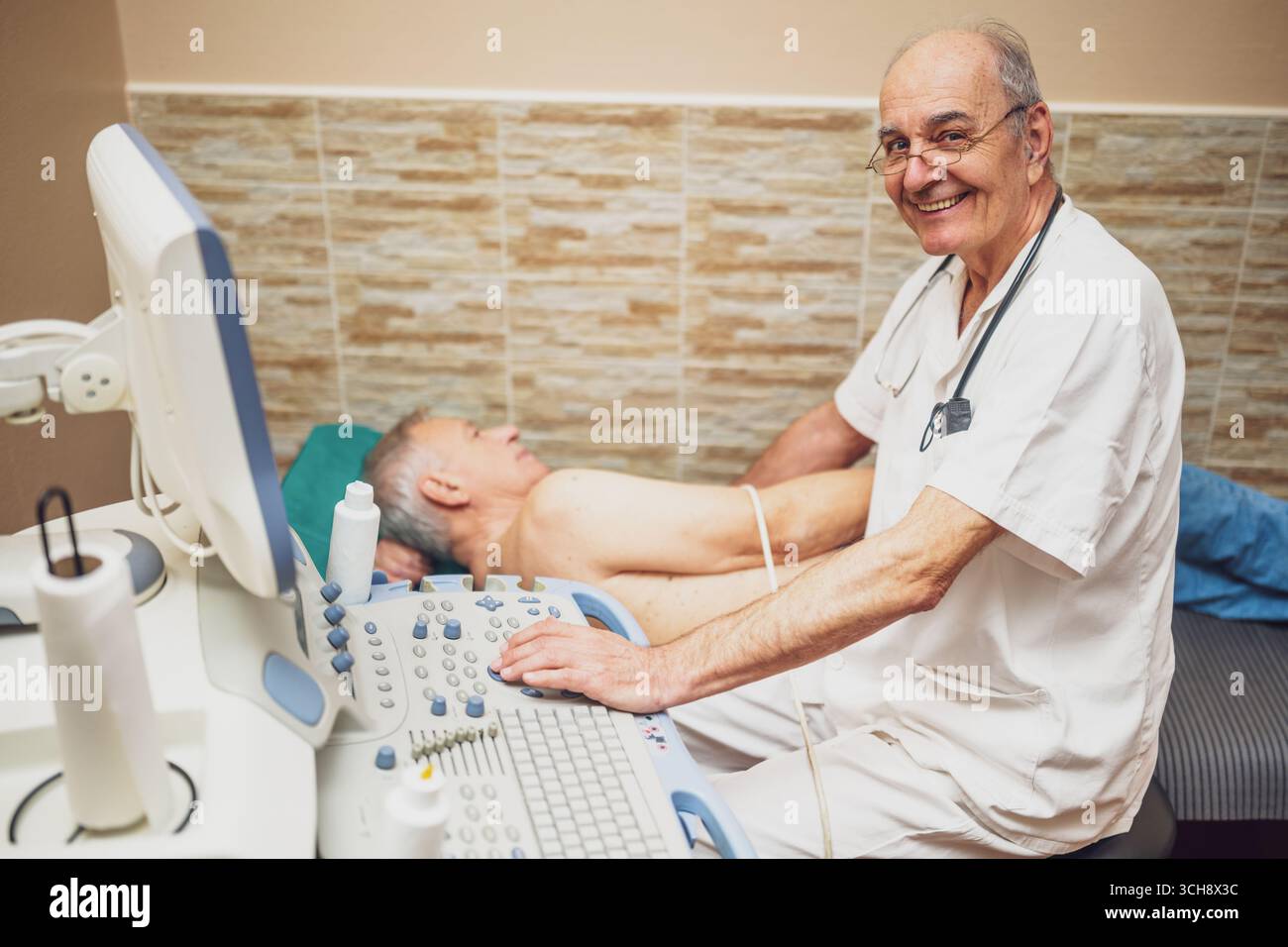 Cardiologist performing an echocardiogram on a senior patient, using ...