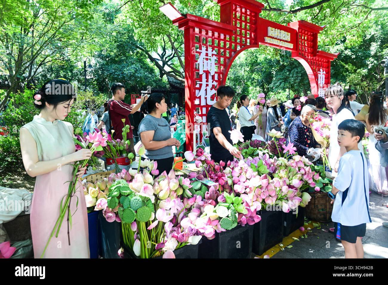 People buy lotus flowers at a lotus fair in Suzhou City, east China's ...
