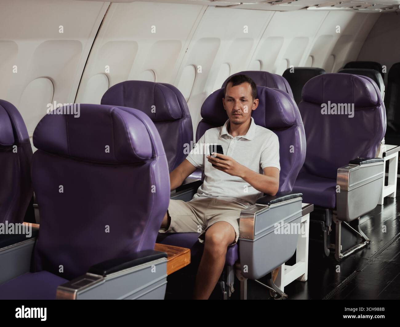 Passenger sitting alone in a nearly empty airplane cabin Stock Photo ...