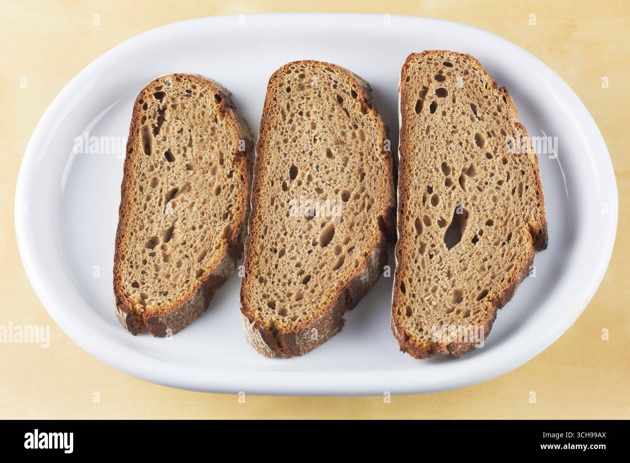 three slices grey bread with dark strong crust acc. german recipe are ...