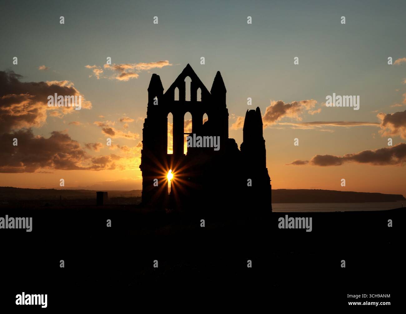 The sun sets behind Whitby Abbey at Whitby , Whitby, United Kingdom ...