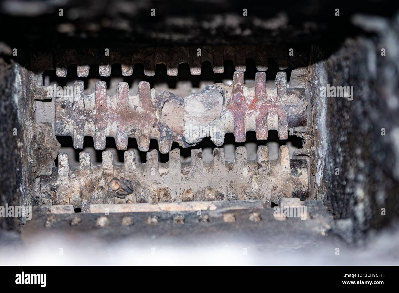 A burnt-out and broken moving grate inside a coal-fired boiler, showing ...