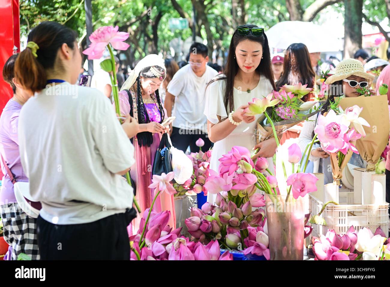 People buy lotus flowers at a lotus fair in Suzhou City, east China's ...