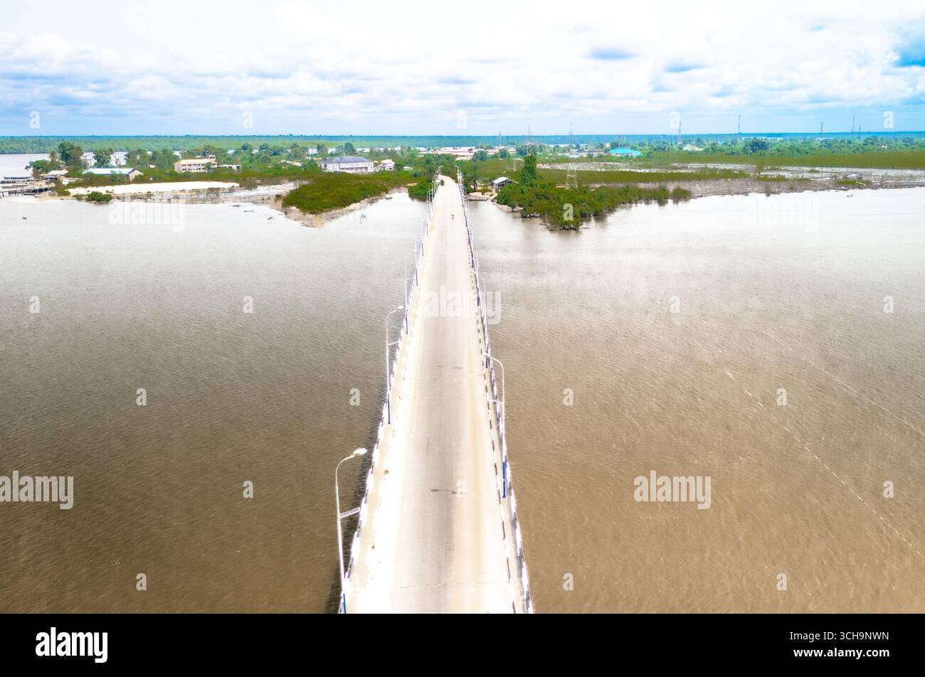 Aerial view of a long bridge stretching across the murky waters ...