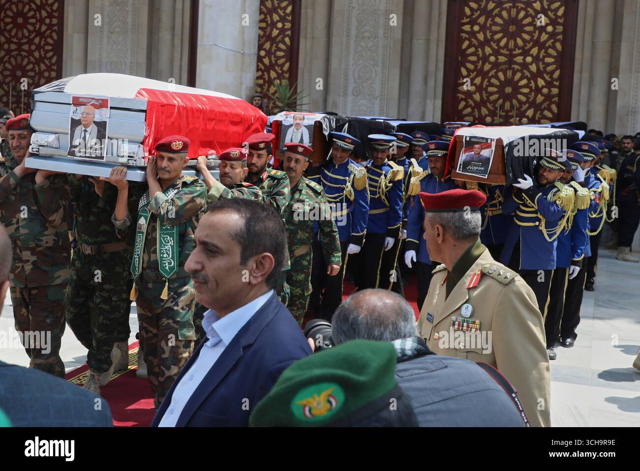 Honor guards carry the coffin of Houthi Prime Minister Ahmed al-Rahawi ...