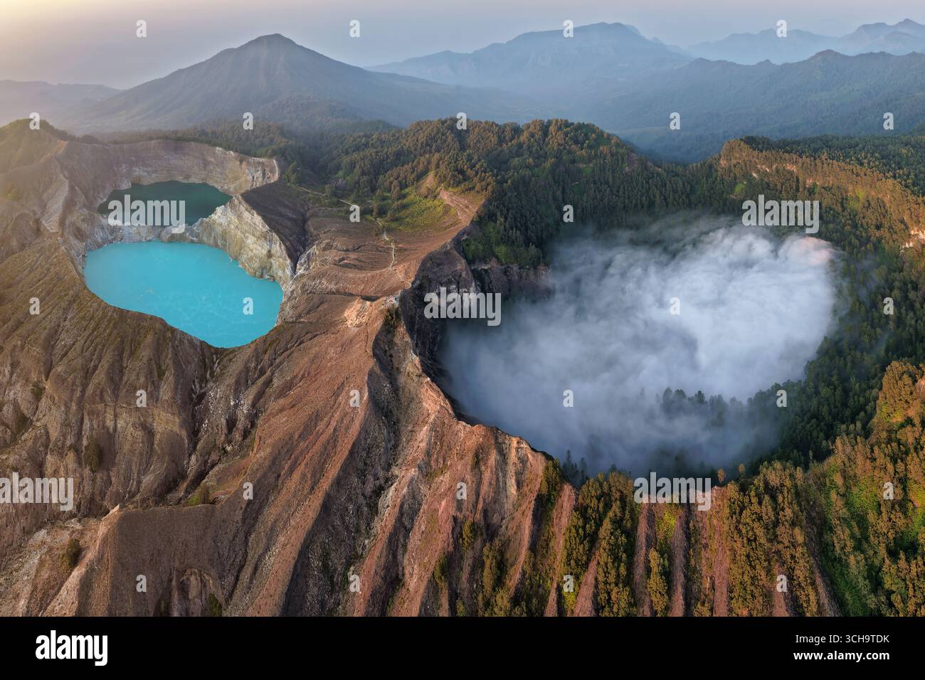Aerial view of the contrasting turquoise and cloud-filled crater lakes ...