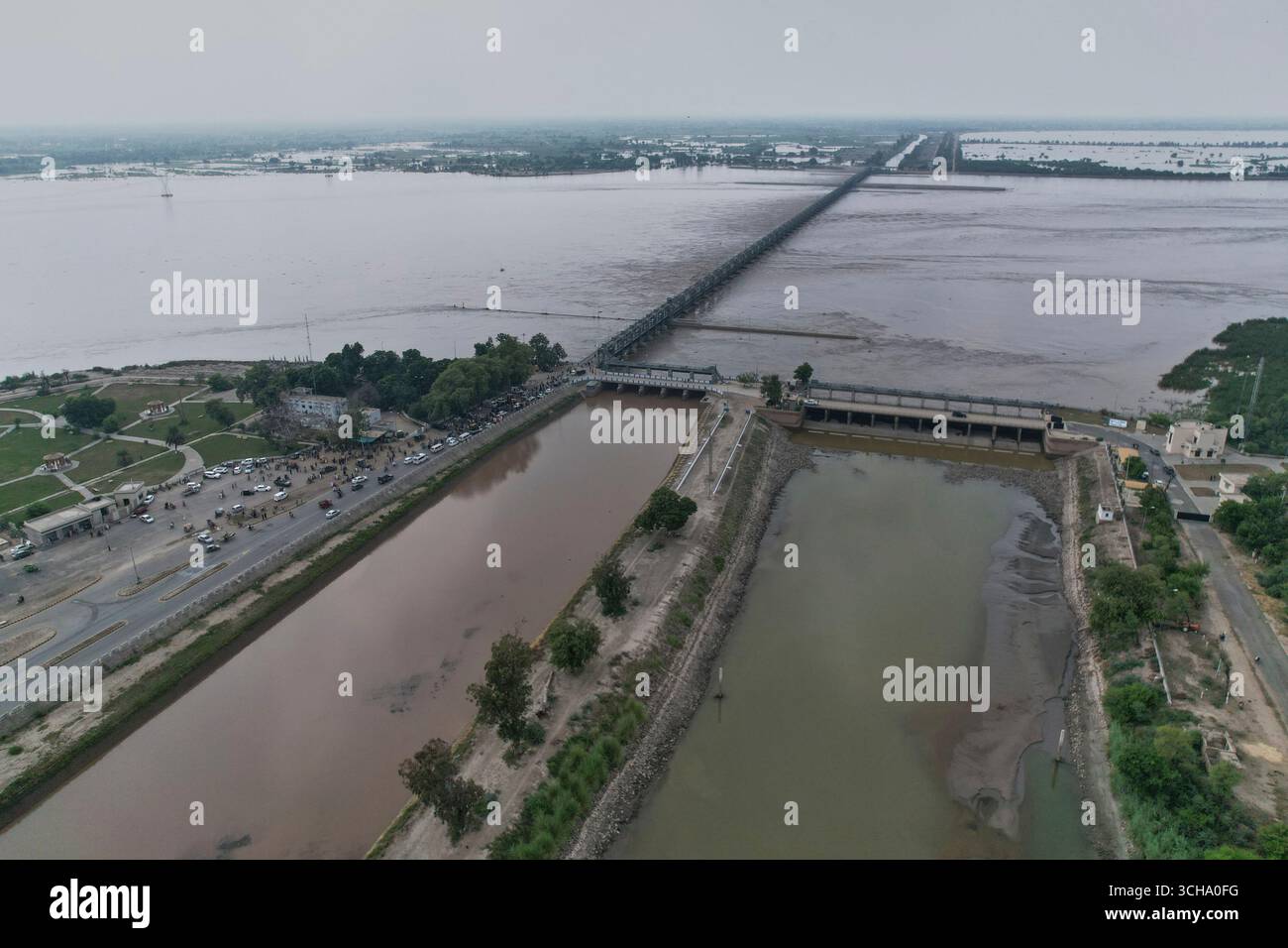 Vehicles drive through Trimmu Barrage on the River Chenab, which ...