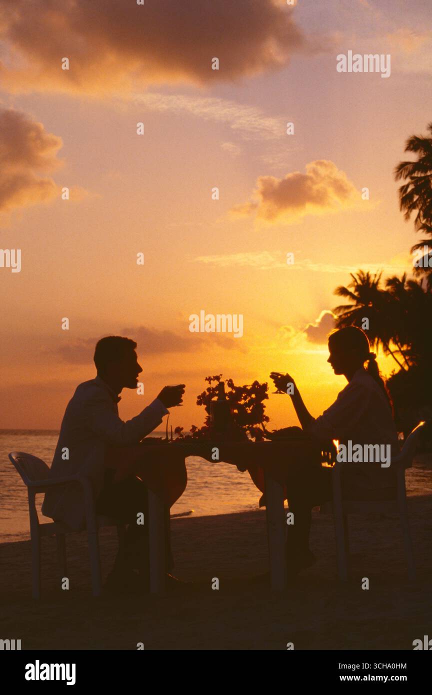 Maldives. Young couple having dinner on tropical beach at sundown Stock ...