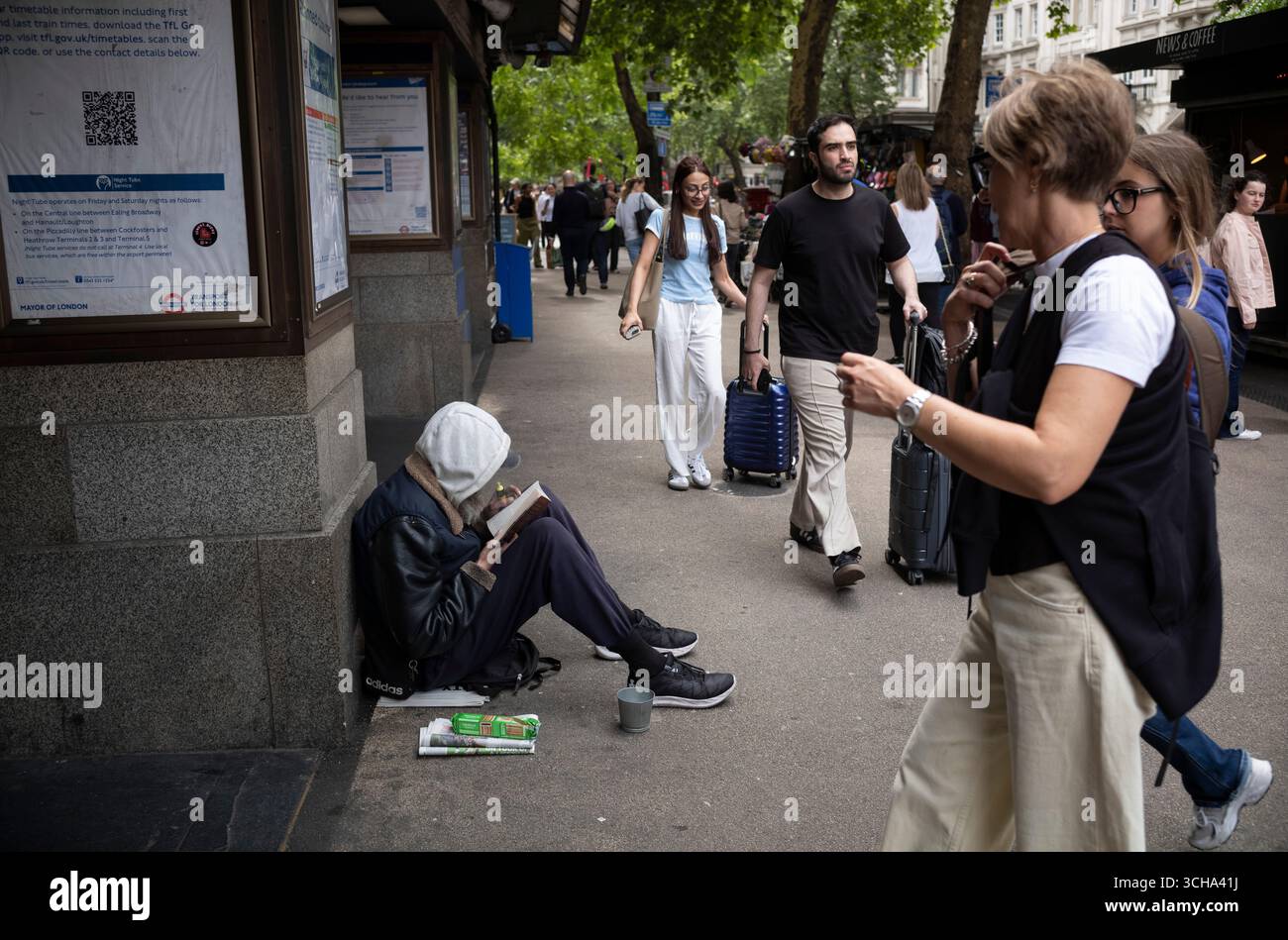 A homeless man sit outside Holborn London Underground station holding ...