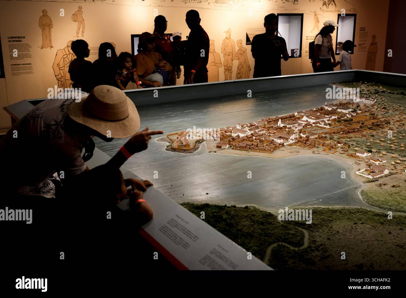 Tourists at the Old Panama Museum look at a topical map of Panama City ...